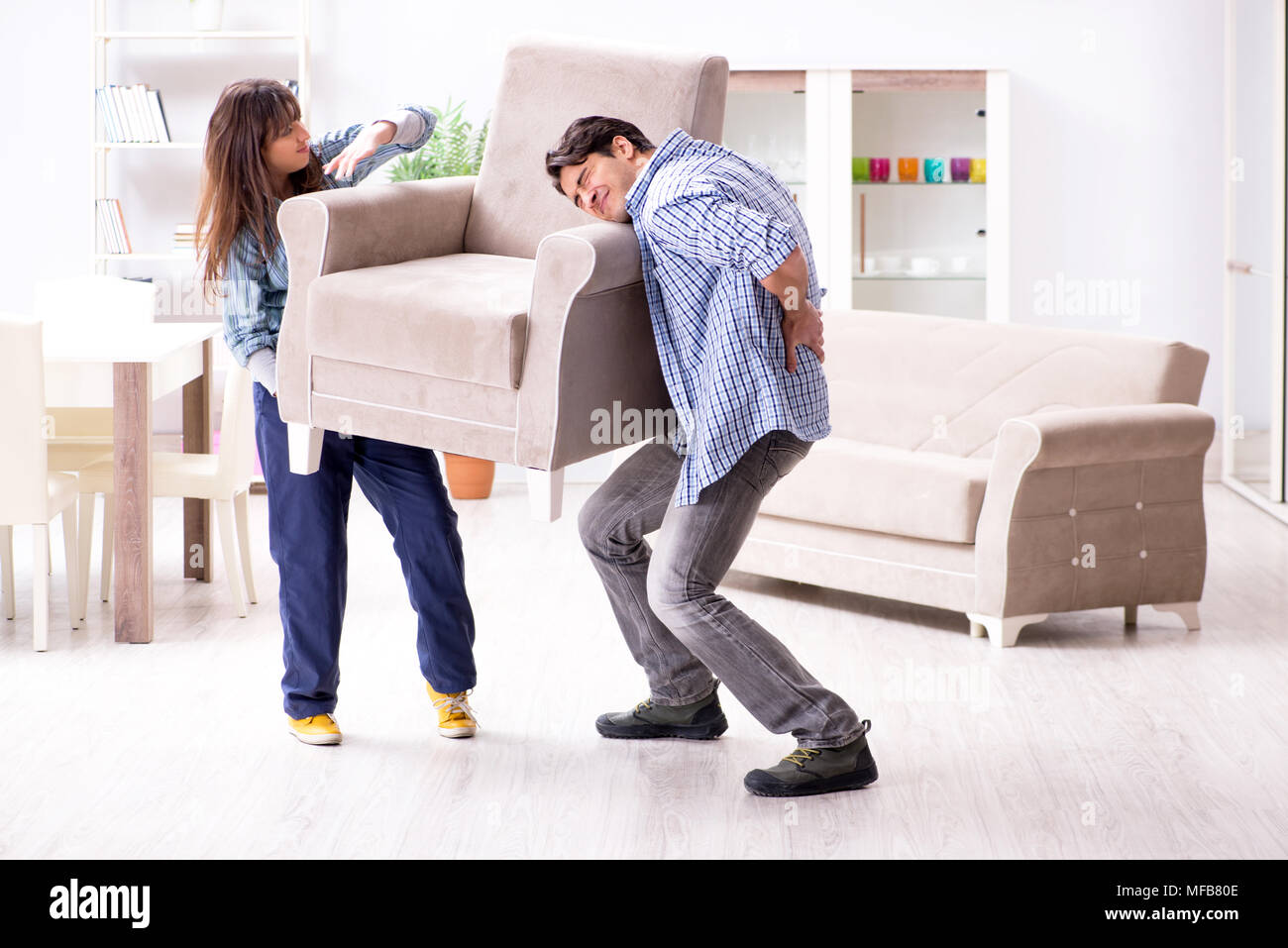 Man moving armchair in the living room Stock Photo - Alamy