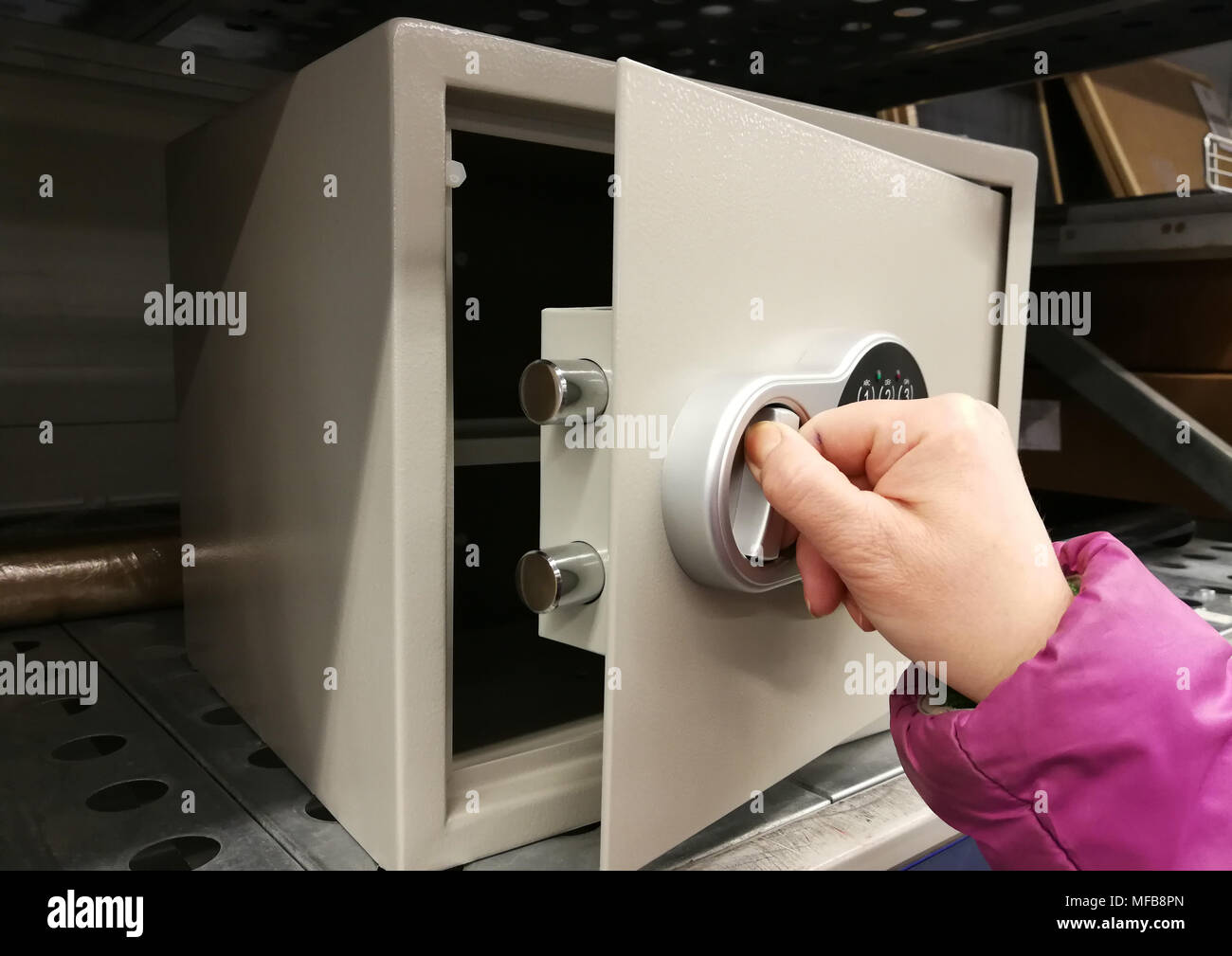 The buyer opens the door of a modern safe on the shop window Stock ...