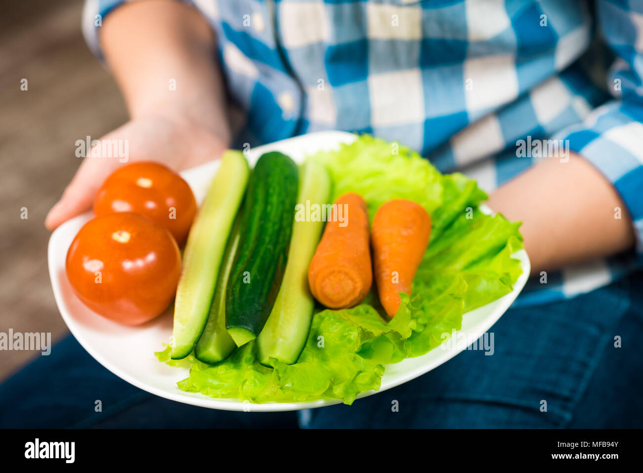 Girl with a plate of vegetables in hands. Healthy eating concept. A ...