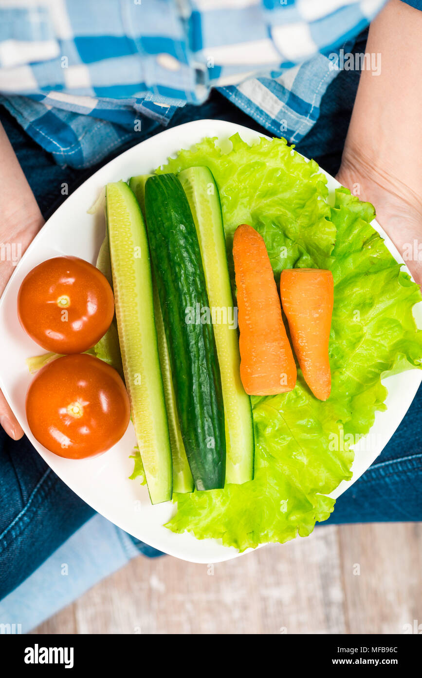 Girl with a plate of vegetables in hands. Healthy eating concept. A ...