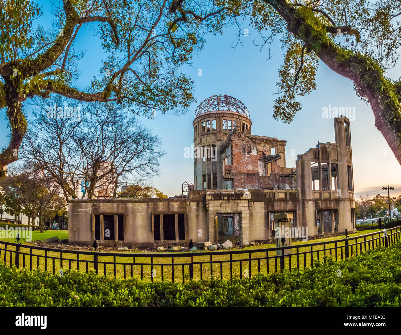 The Hiroshima A-Bomb Dome framed by tall trees in the surrounding Peace ...