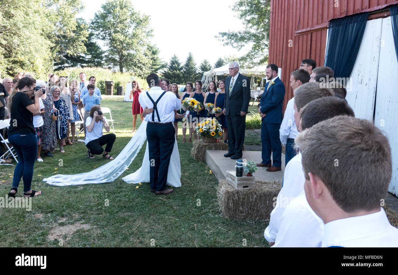 Father of the bride gets a big hug from his daughter while minister ...