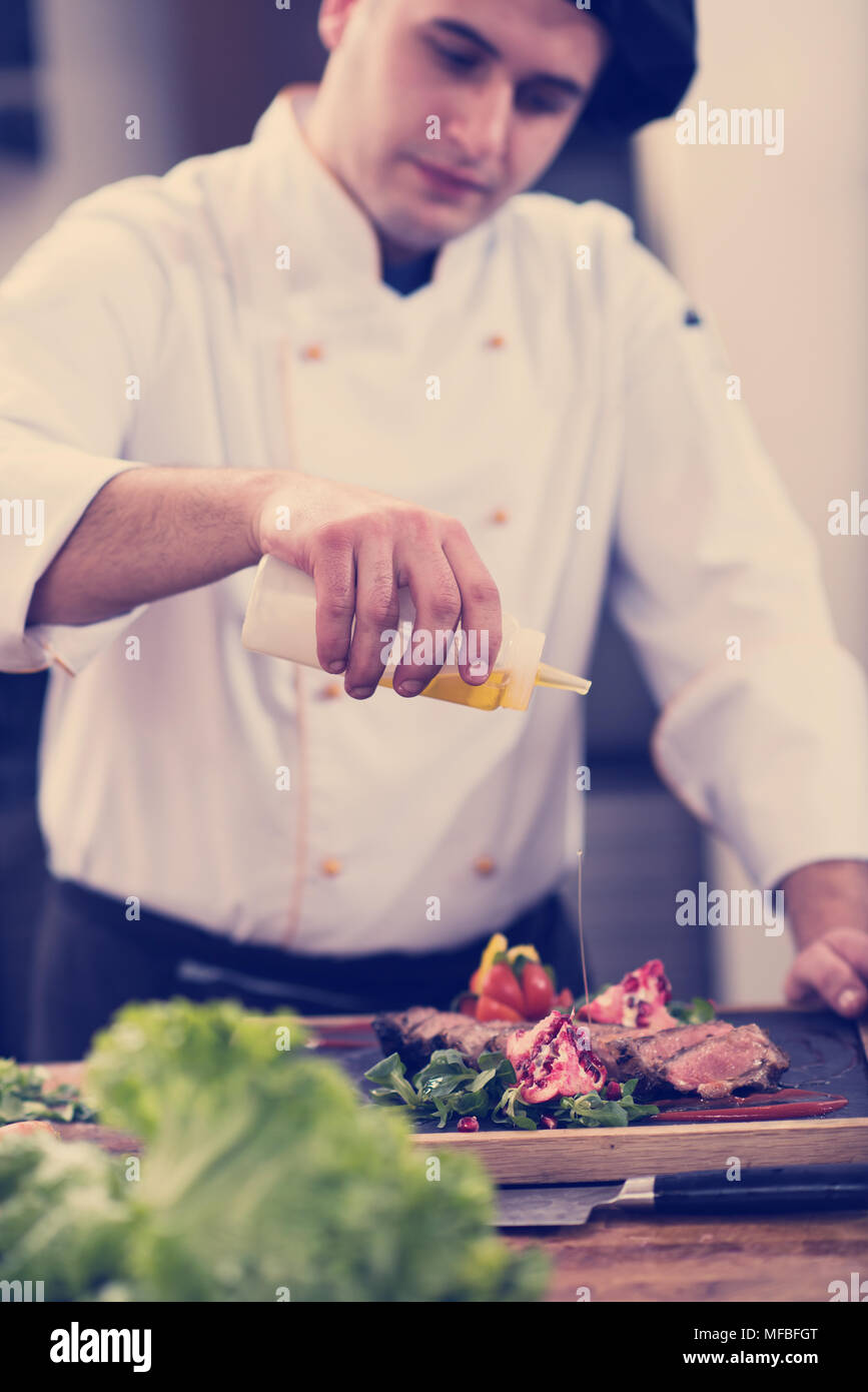 Chef finishing steak meat plate with Finally dish dressing and almost ...