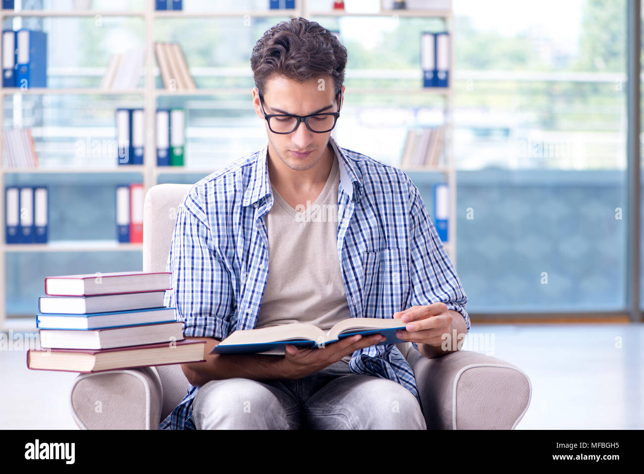 Student reading books and preparing for exams in library Stock Photo ...