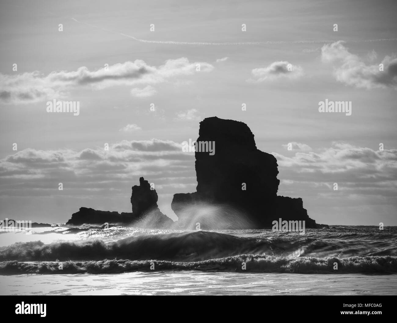 Sea stack sharp silhouette by sunset sky. Evening light on the rocks ...