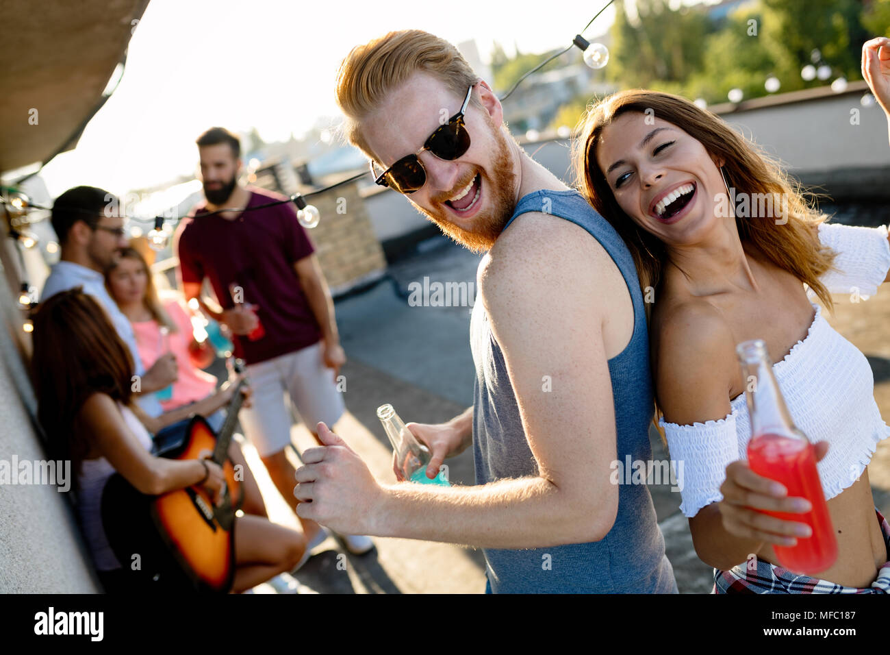 Friends having fun at rooftop party Stock Photo - Alamy