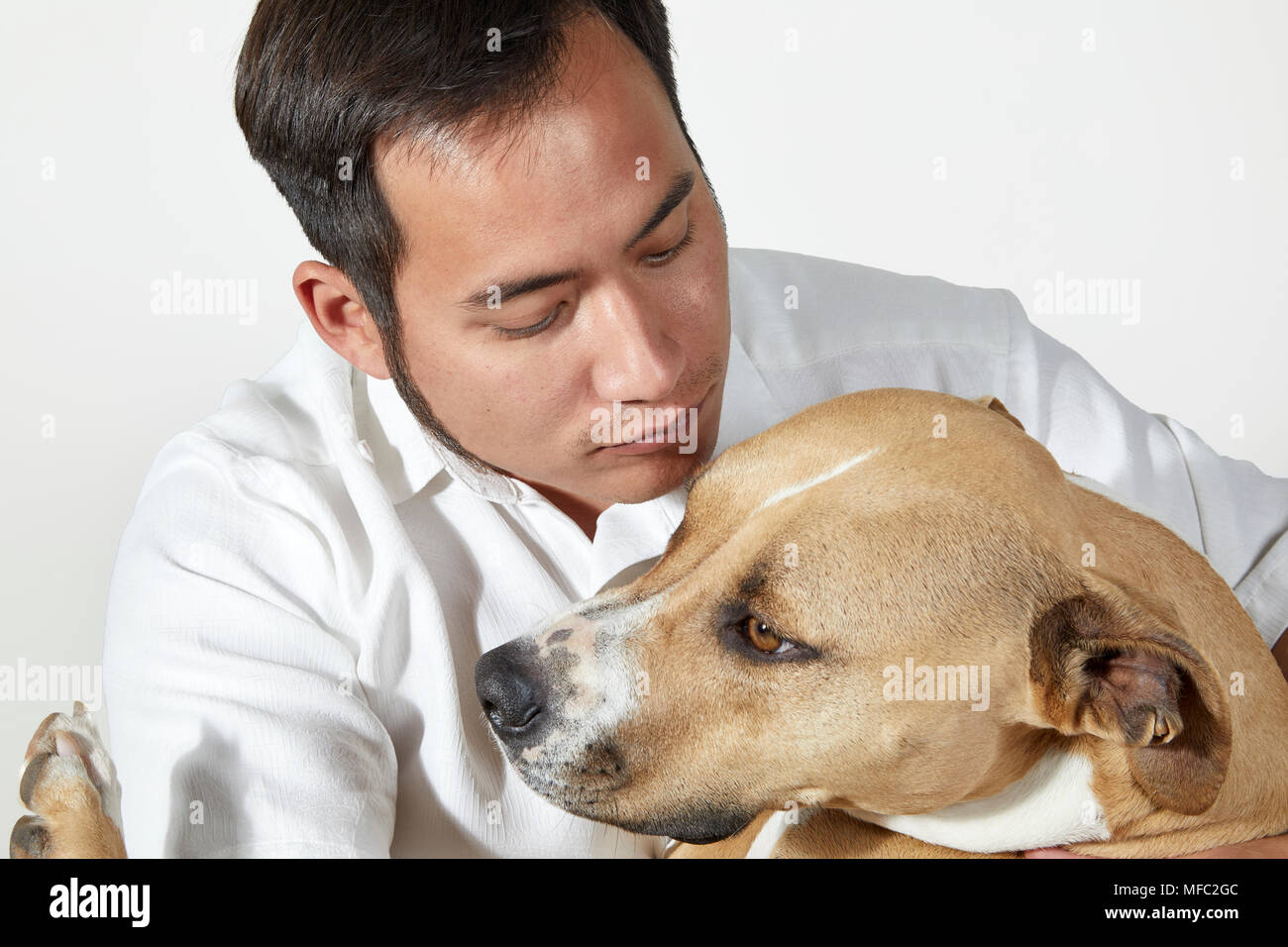 Young Adult man giving a big dog a hug Stock Photo - Alamy