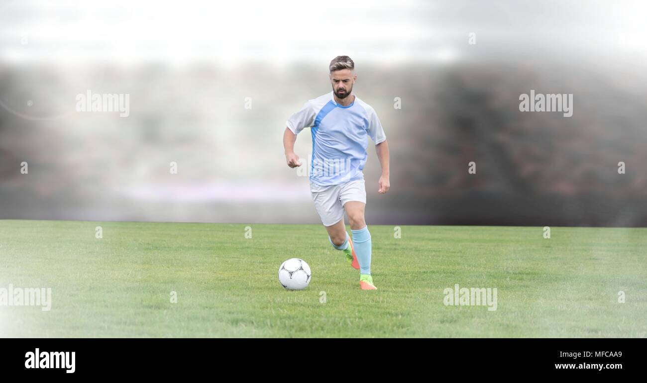 Soccer player on grass with stadium Stock Photo - Alamy