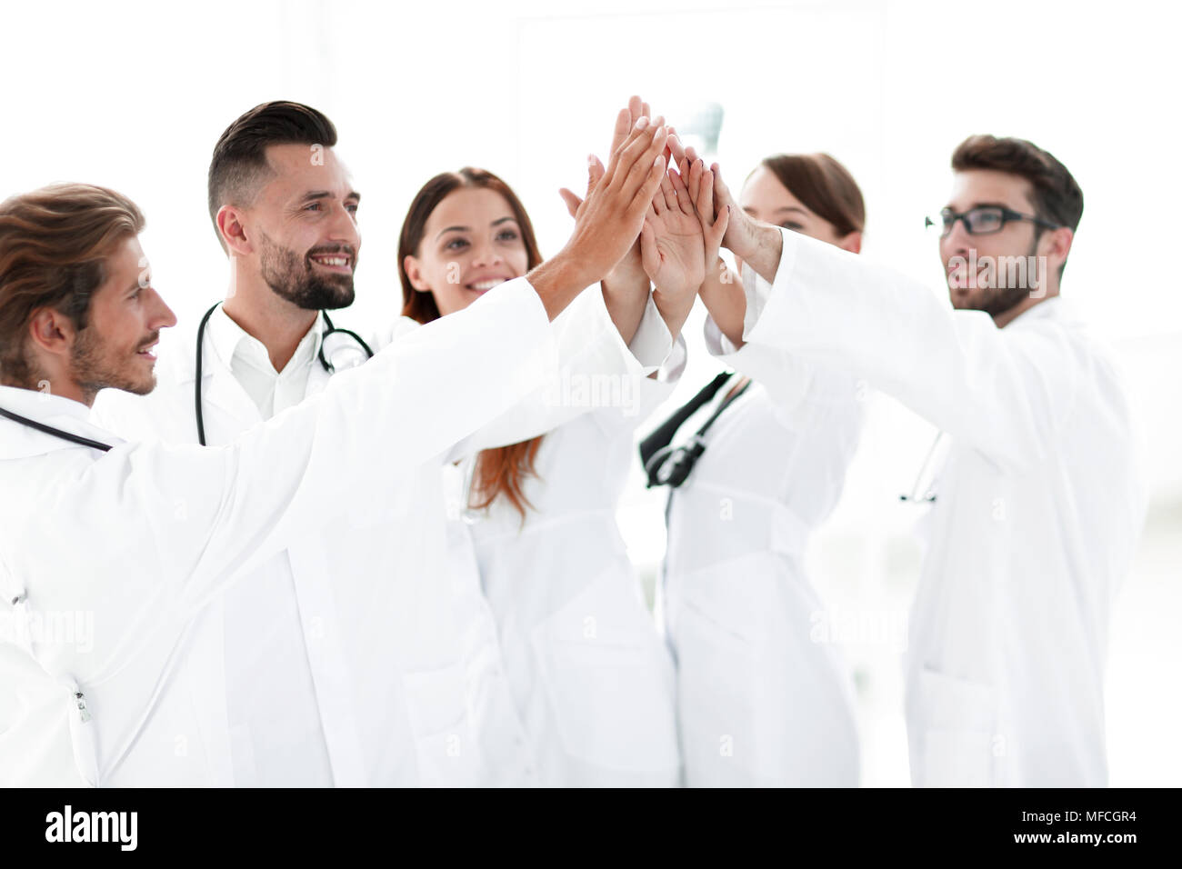 group of doctors giving each other a high five Stock Photo - Alamy
