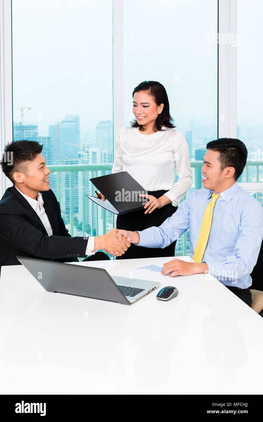 Asian banker counseling man in office Stock Photo - Alamy