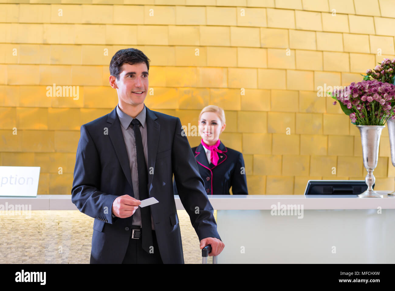 Hotel receptionist check in man giving key card Stock Photo - Alamy