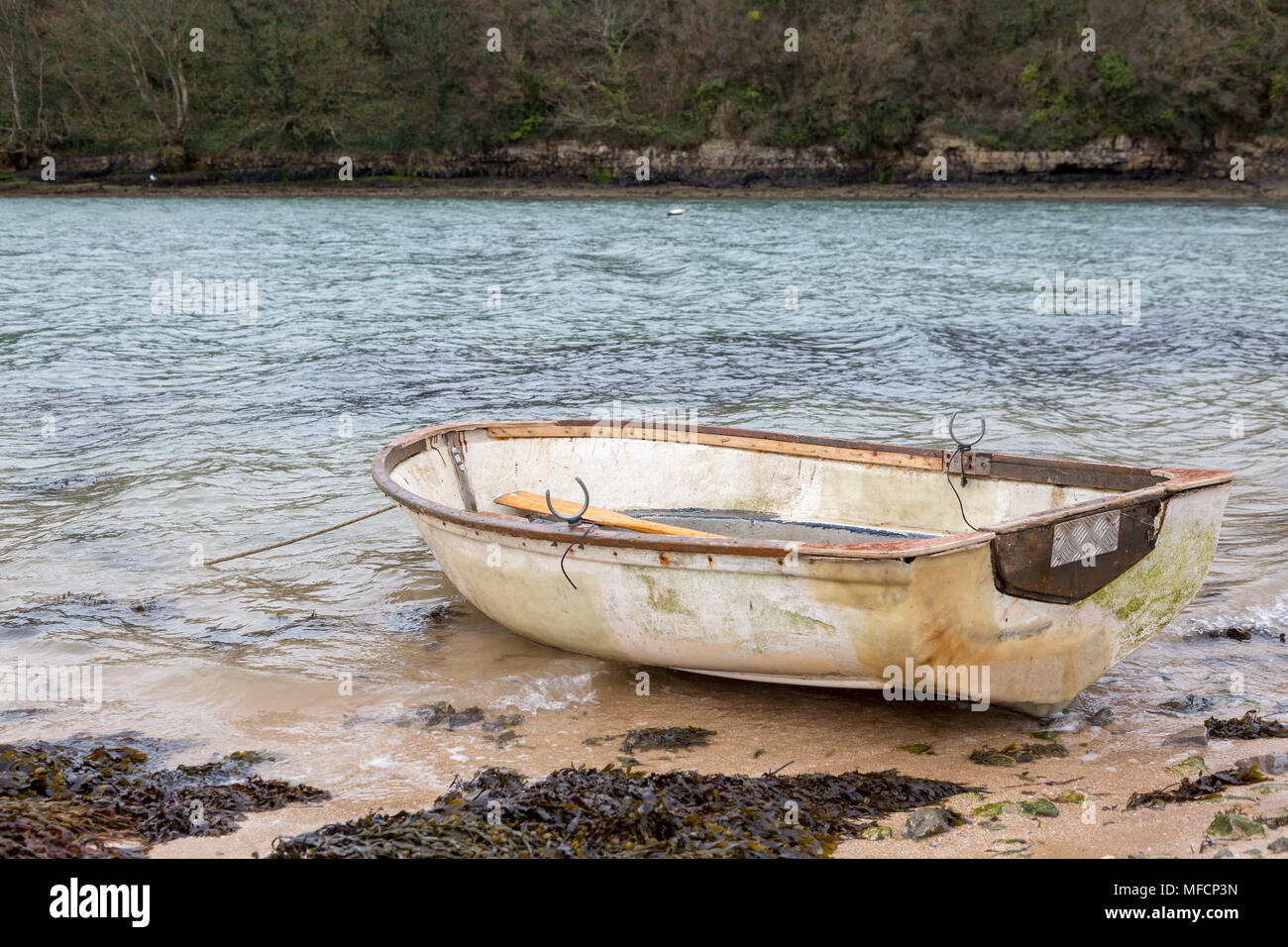 Small rowing boat moored on the beach Stock Photo - Alamy