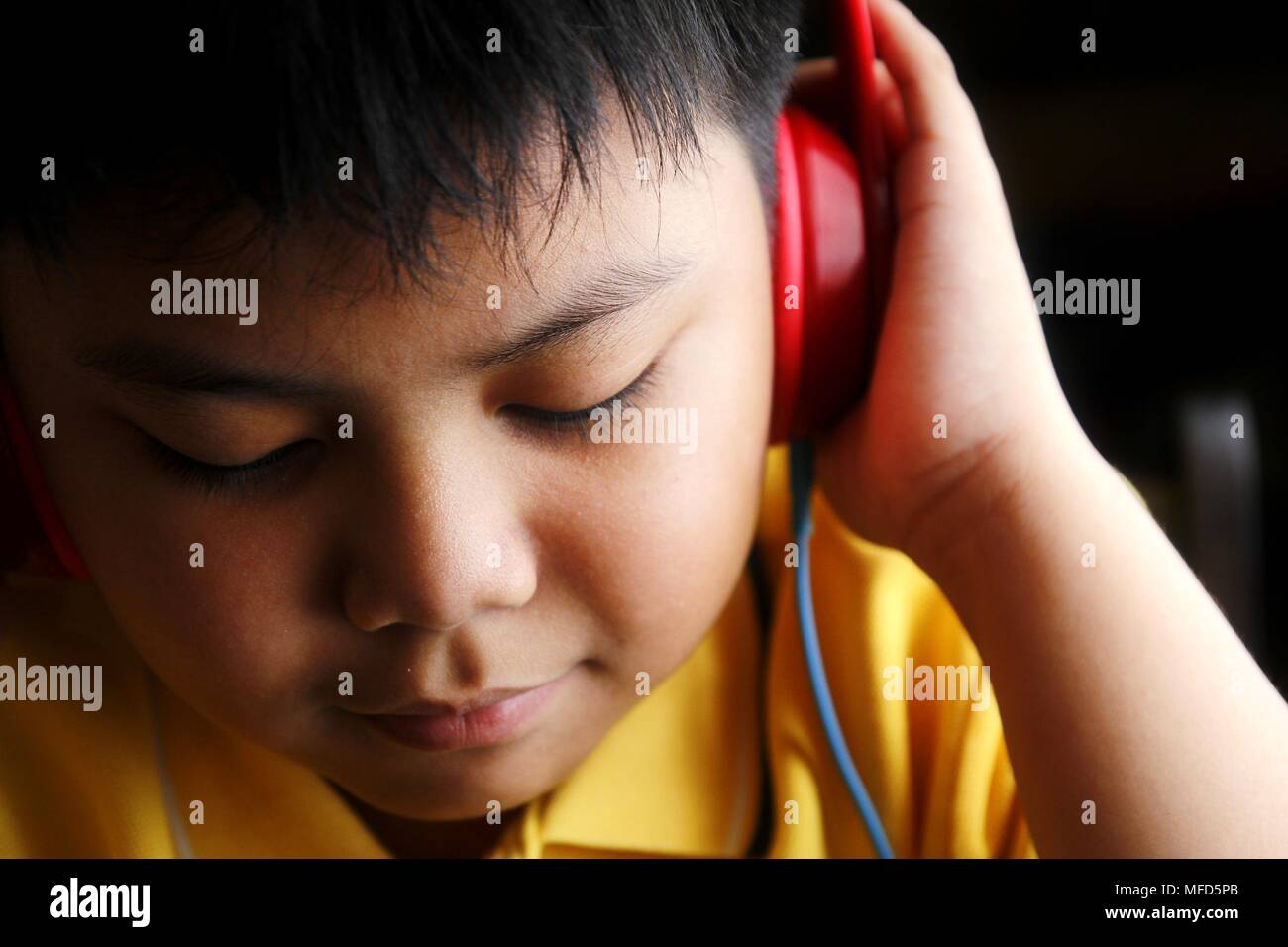 Photo of a young Asian boy with headphones Stock Photo - Alamy