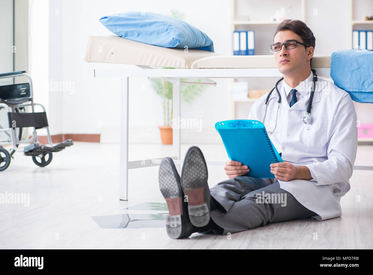 Doctor sitting on the floor in hospital Stock Photo - Alamy