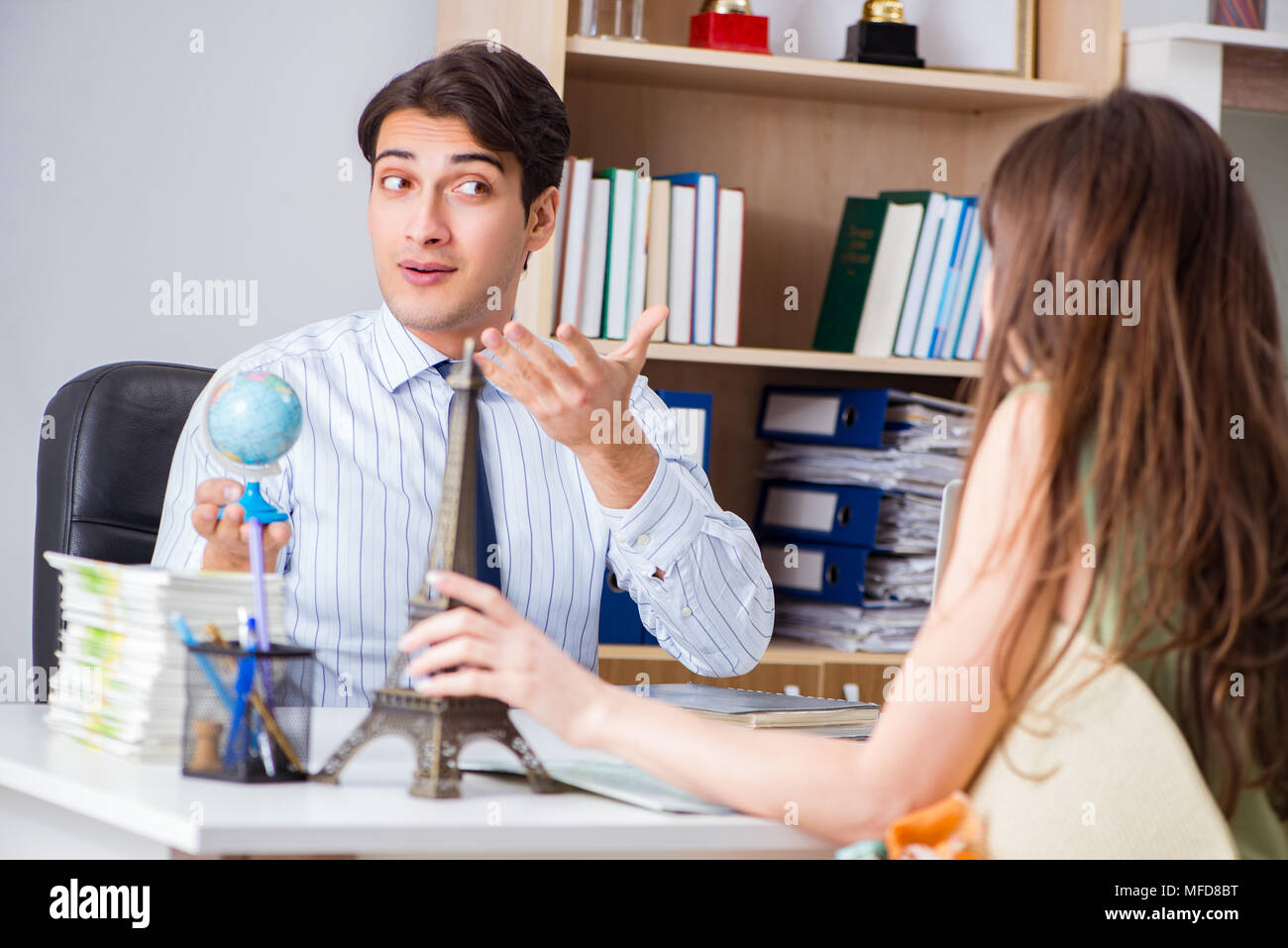 Customer visiting travel agency and talking to agent Stock Photo - Alamy