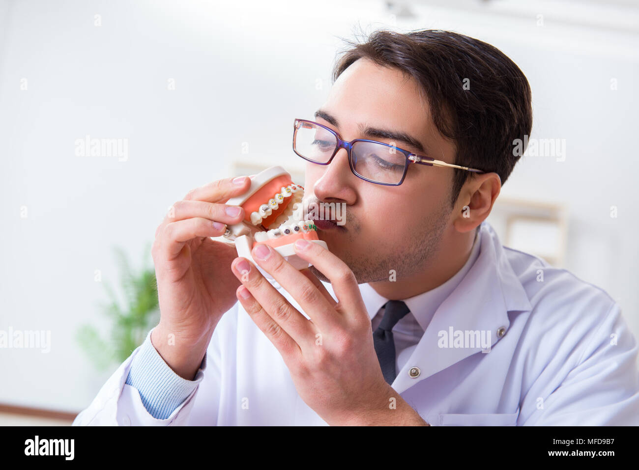 Funny dentist with teeth model in hospital Stock Photo - Alamy