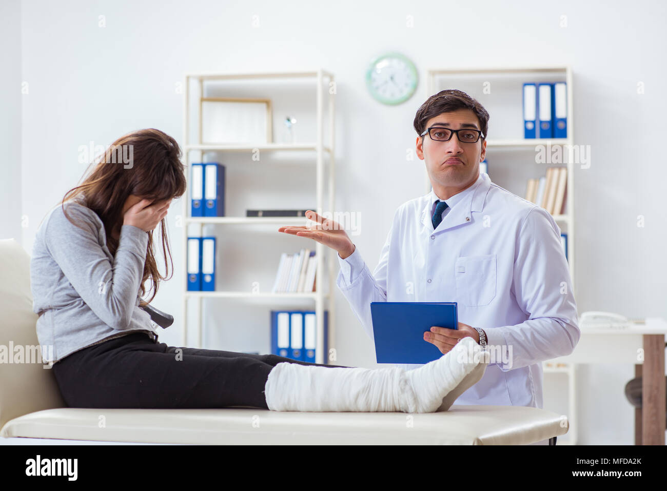 Doctor examining patient with broken leg Stock Photo - Alamy