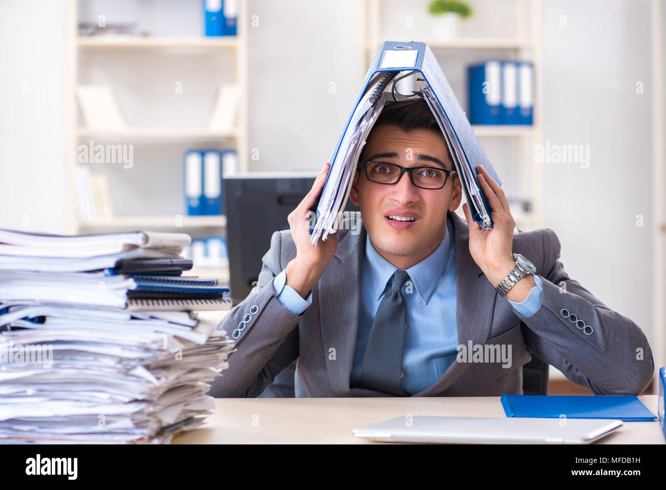 Overloaded with work employee under paperwork burden Stock Photo - Alamy