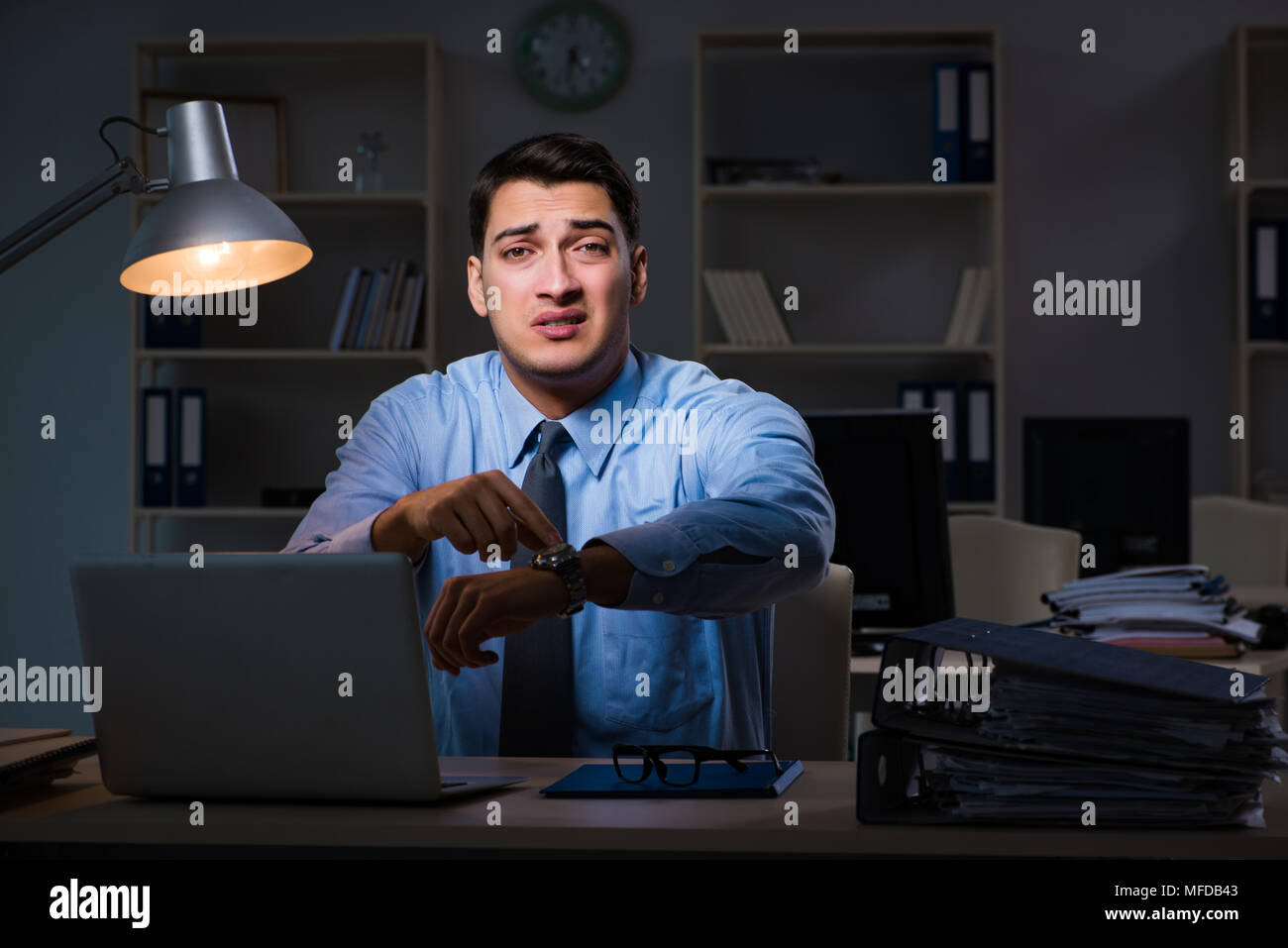 Employee working late at night at important report Stock Photo - Alamy