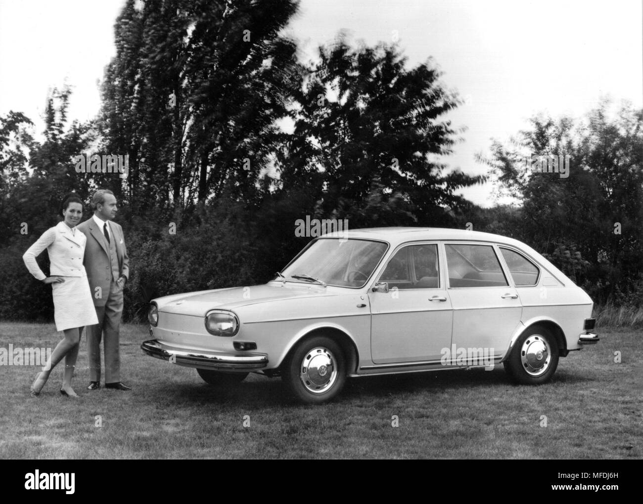 A pair stands next to a Volkswagen VW 411. The car belongs to the ...