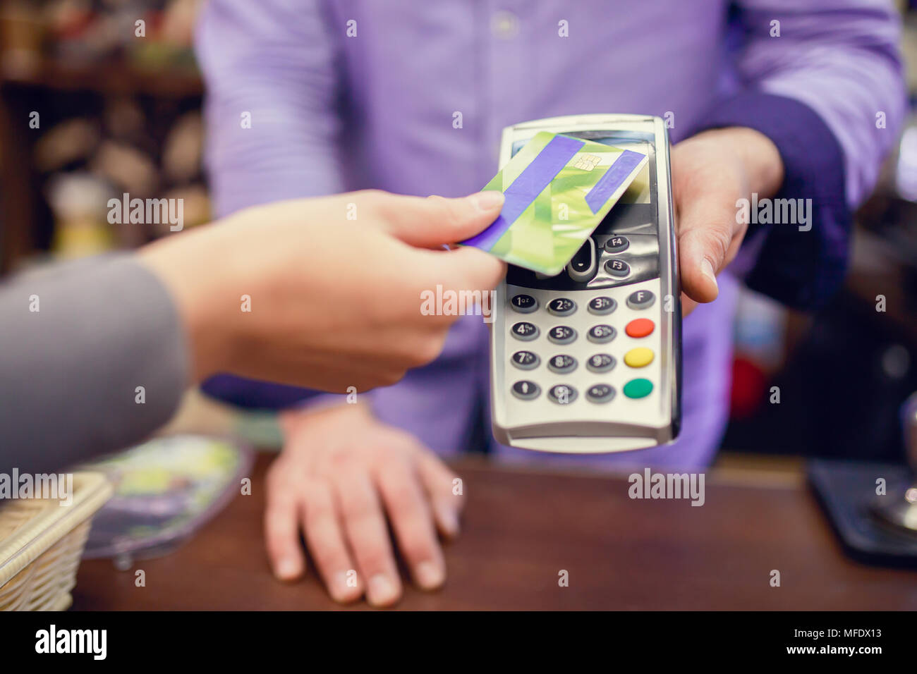 Picture of buyer man with bank card and seller with terminal in hand ...