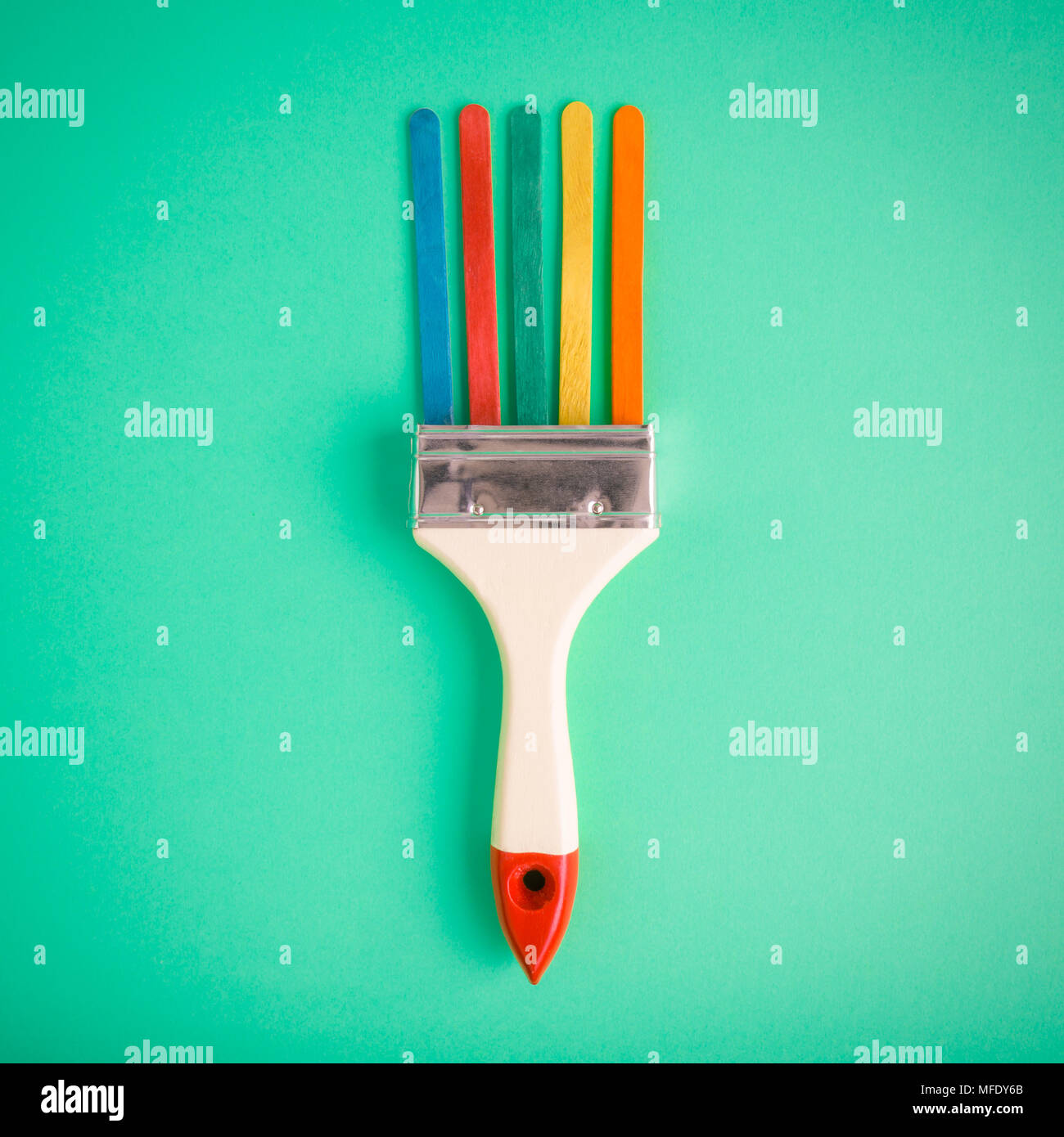 Paintbrush with colorful ice cream sticks on pastel green background ...