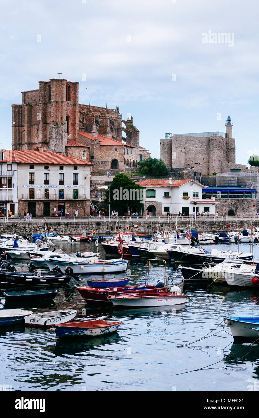 Boats moored at the port with Santa María de la Asunción church, the ...