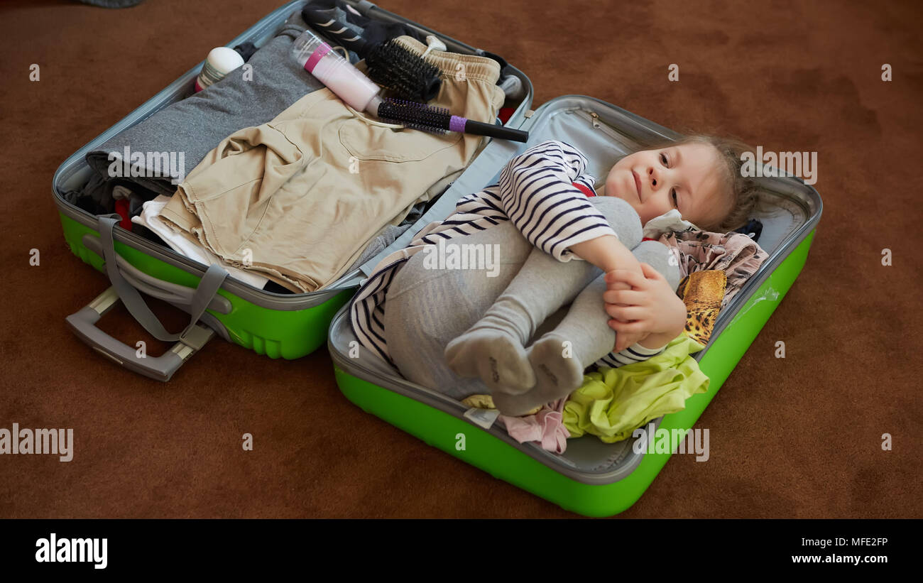 Cute little child inside a big suitcase. Film effect Stock Photo - Alamy