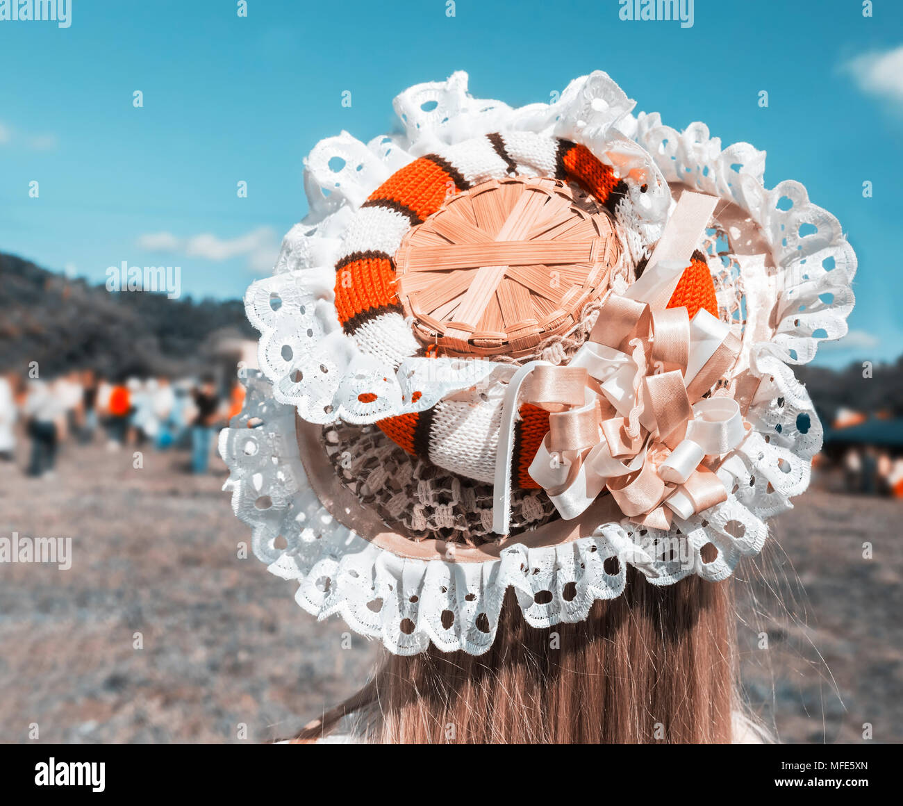On the girl's head is an original hat, decorated with lace and ribbons ...