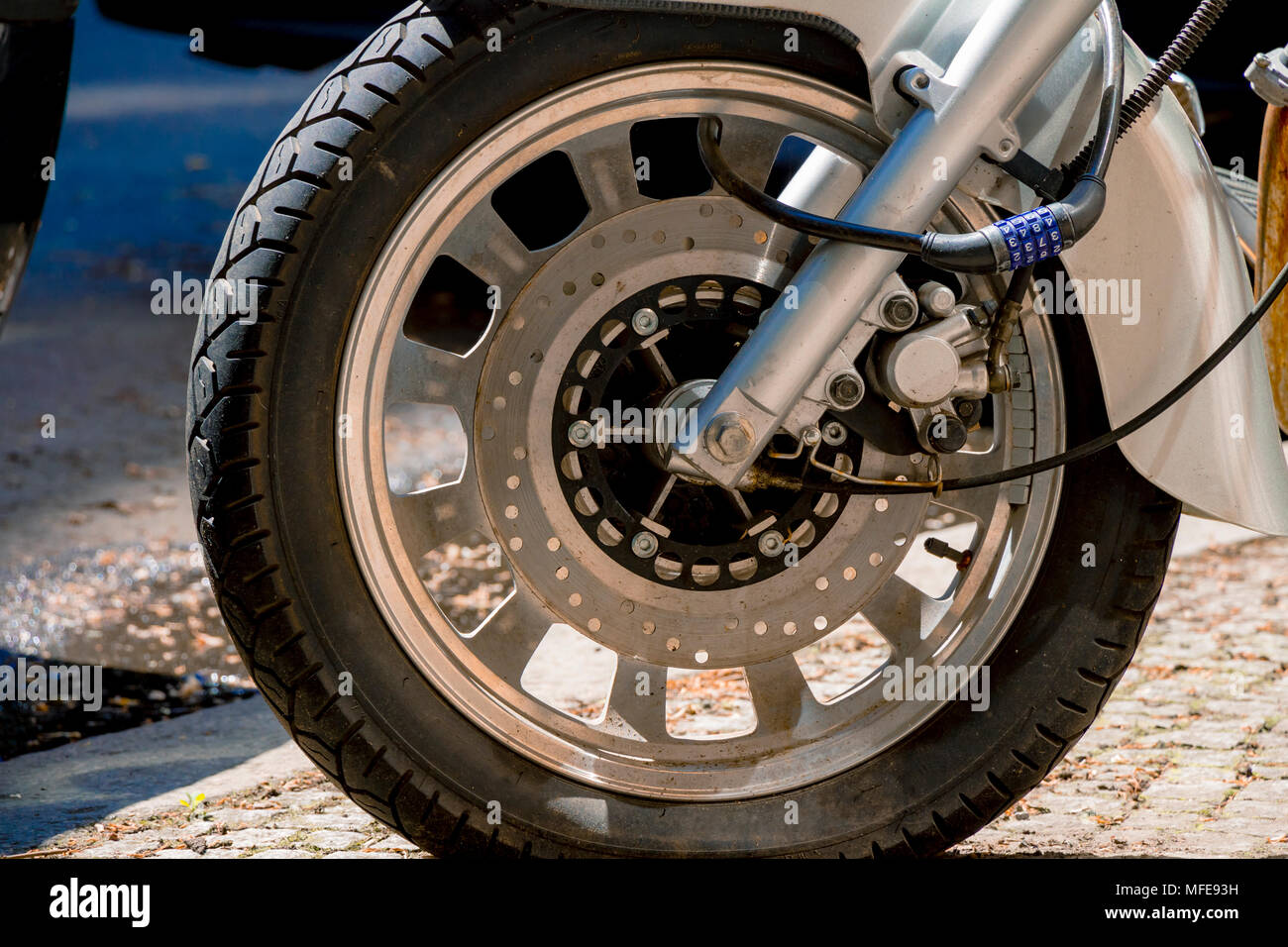 Security number padlock blocking motorcycle wheel on the street Stock ...