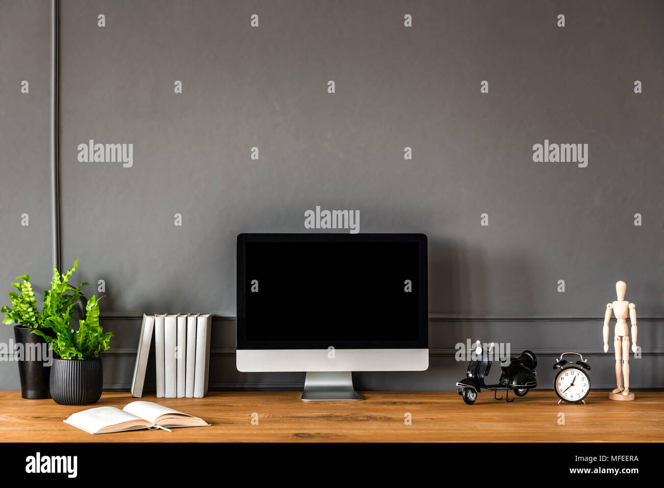 Books, plants and computer monitor in workspace interior with copy ...