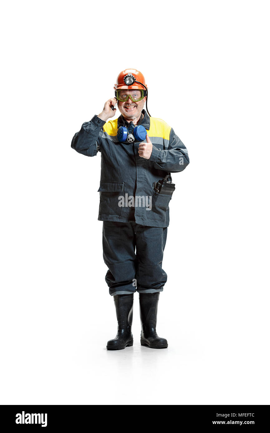 The studio shot of happy senior bearded male miner standing at the ...