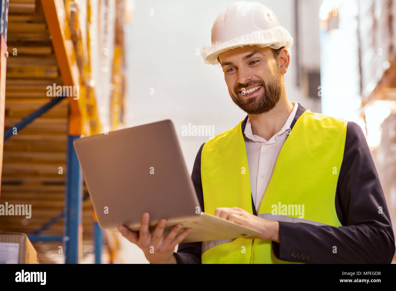 Positive delivery manager using a laptop Stock Photo - Alamy