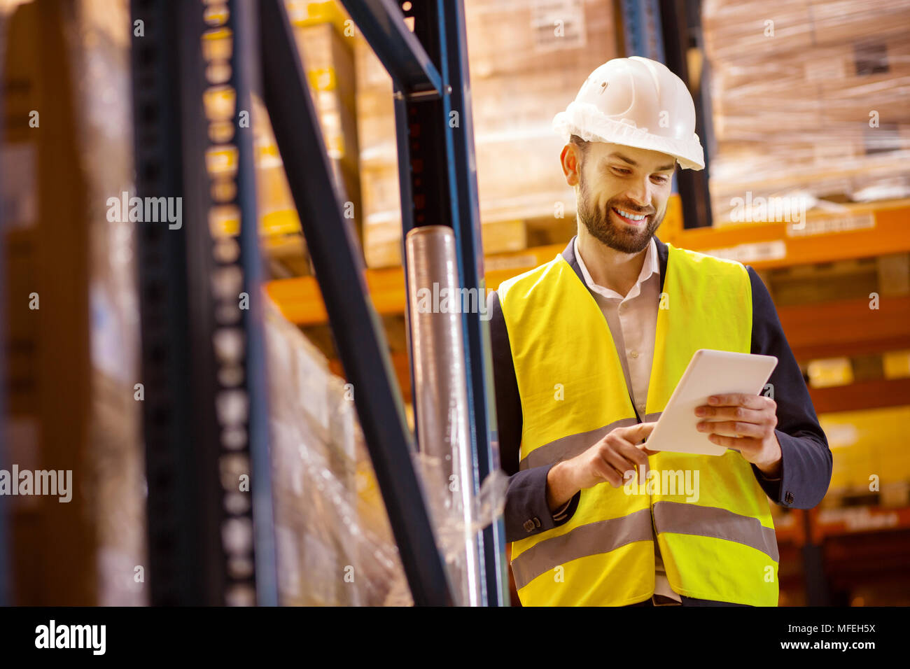 Positive smart manager looking at his tablet Stock Photo - Alamy