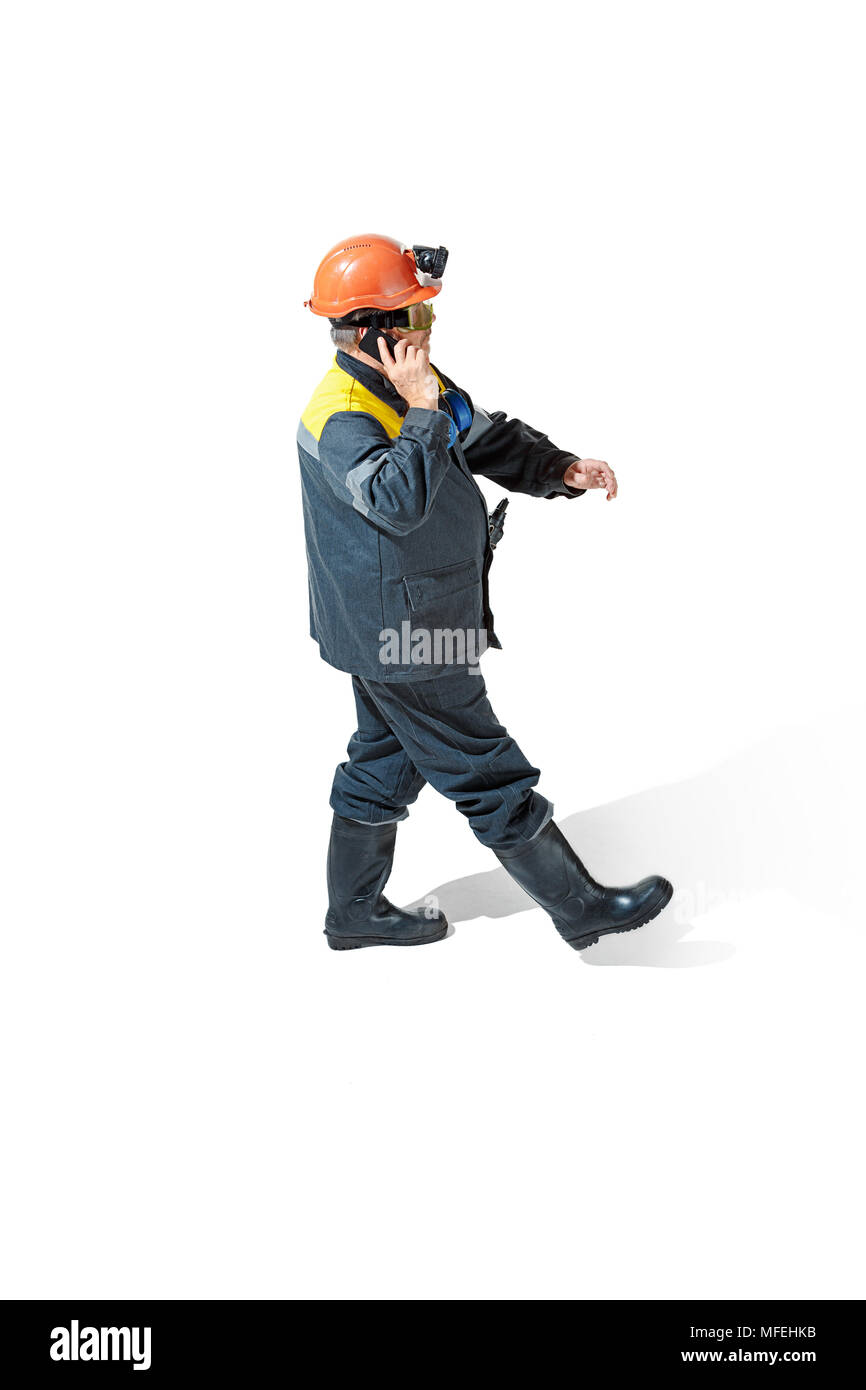 The studio shot of senior bearded male miner standing at the camera on ...