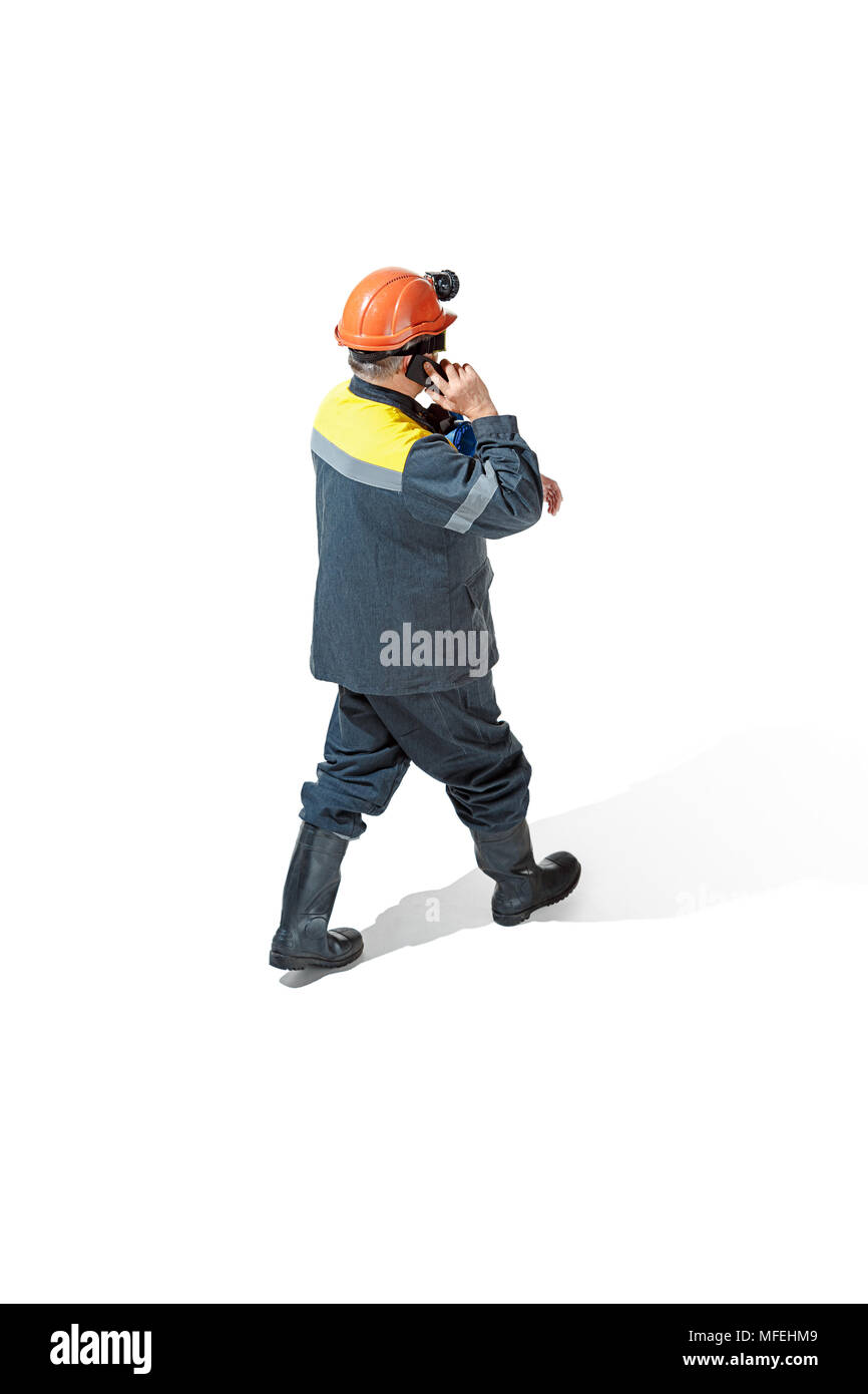 The studio shot of senior bearded male miner standing at the camera on ...