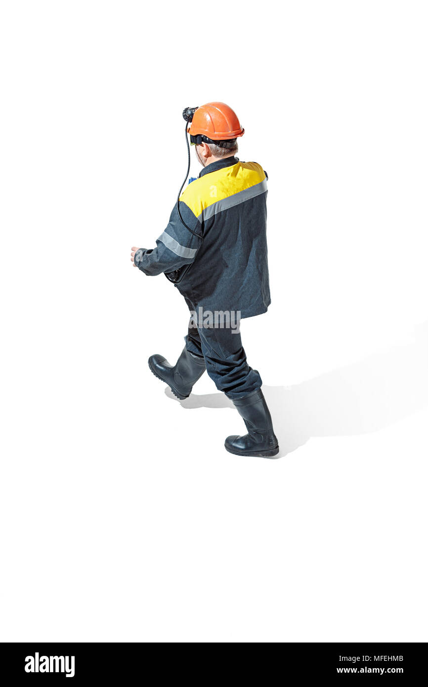 The studio shot of senior bearded male miner standing at the camera on ...