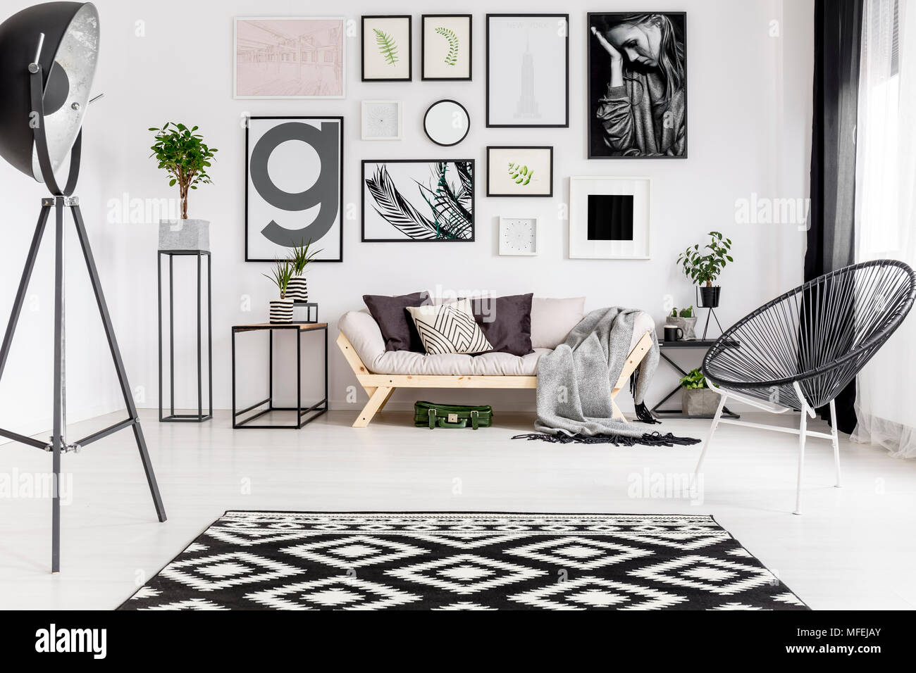 Gallery of posters above settee in modern living room interior with ...