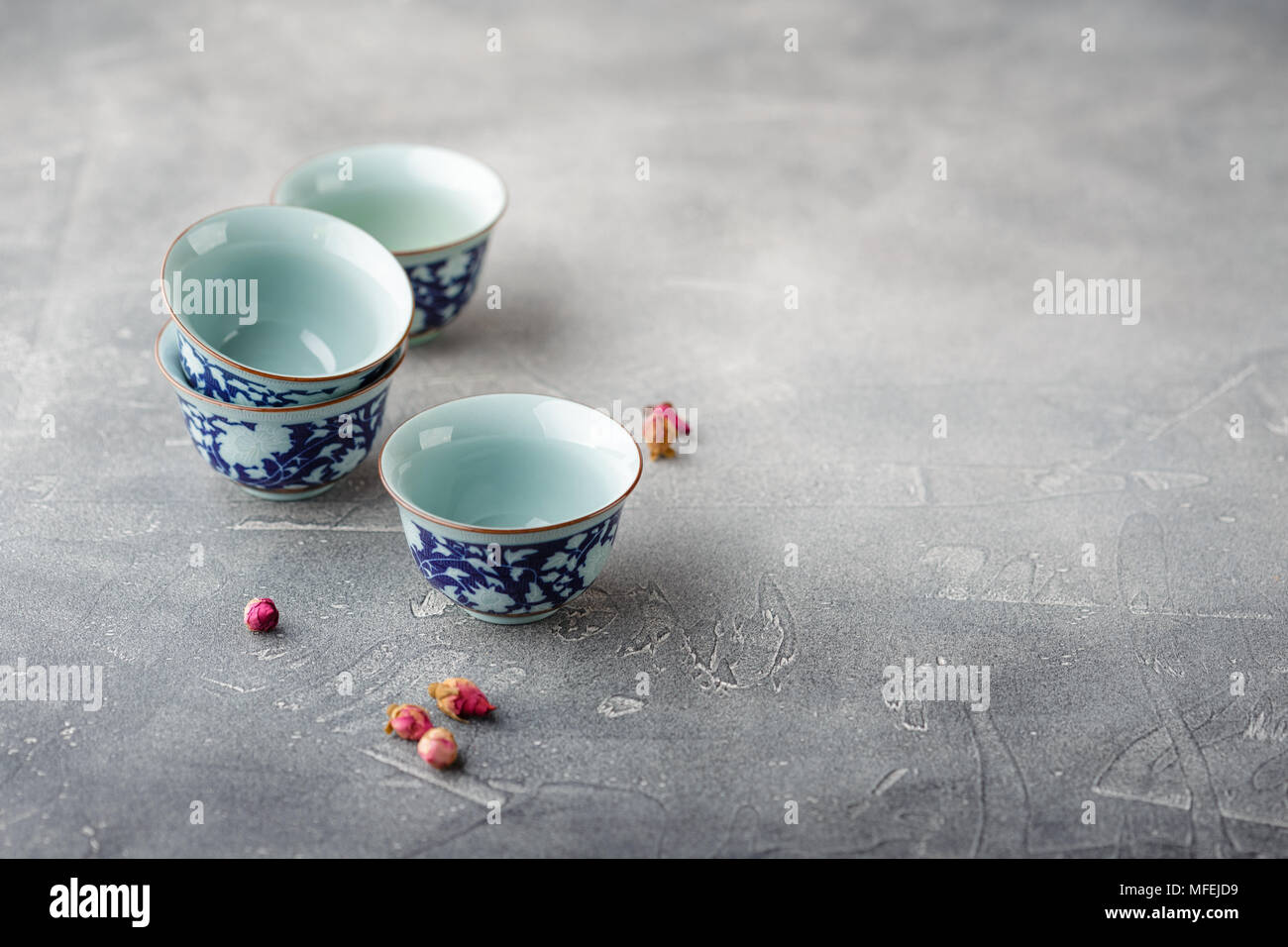 Empty Chinese tea cups with a blue pattern and dry buds of roses on a ...
