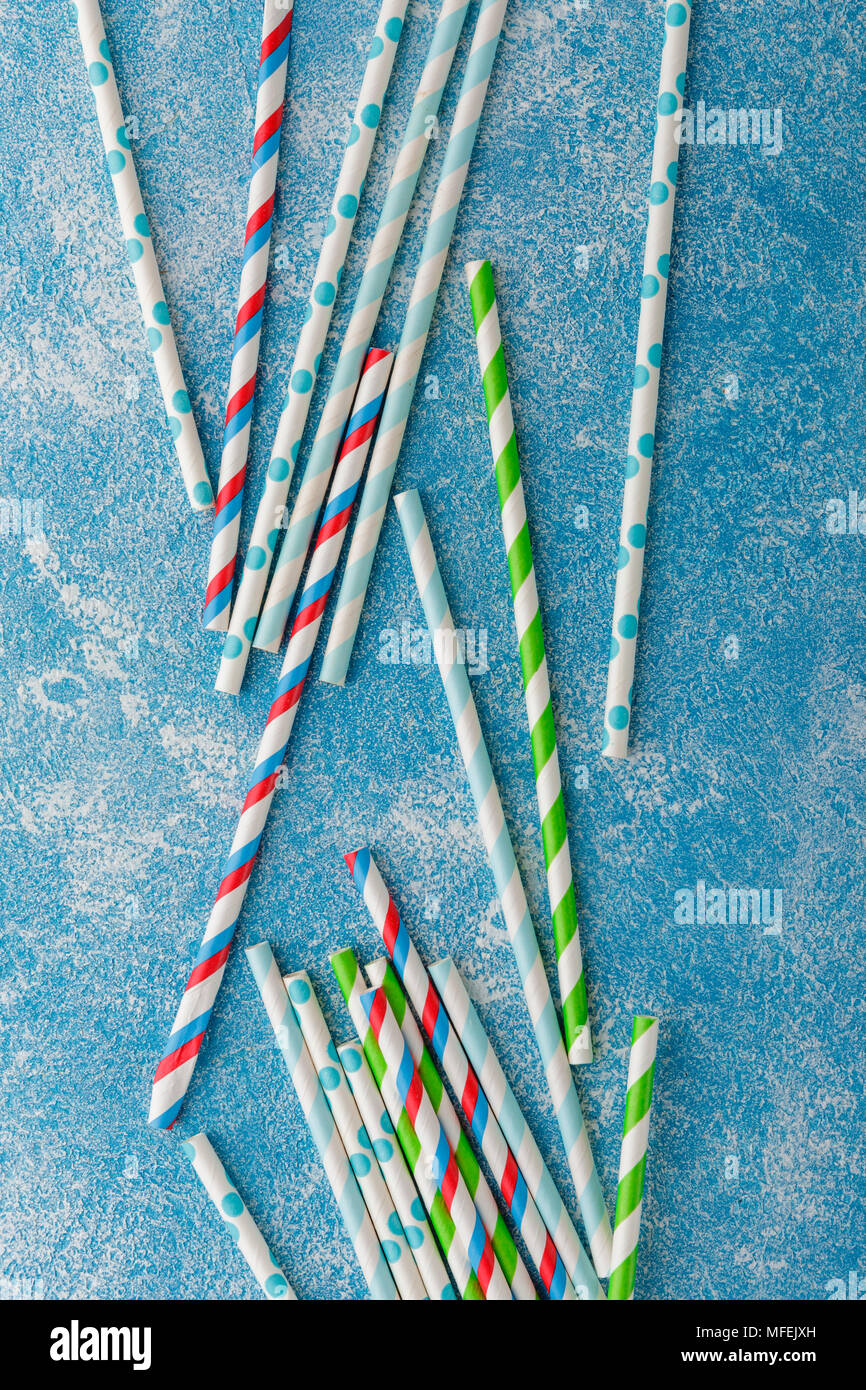 Background of Striped drink paper straws in different colors on blue ...