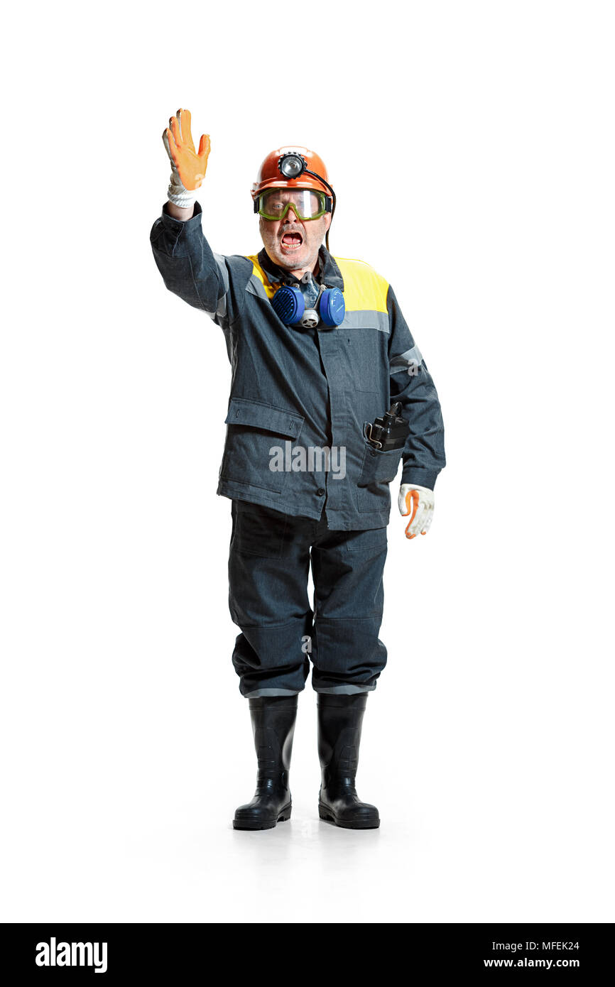 The studio shot of senior bearded male miner standing at the camera on ...