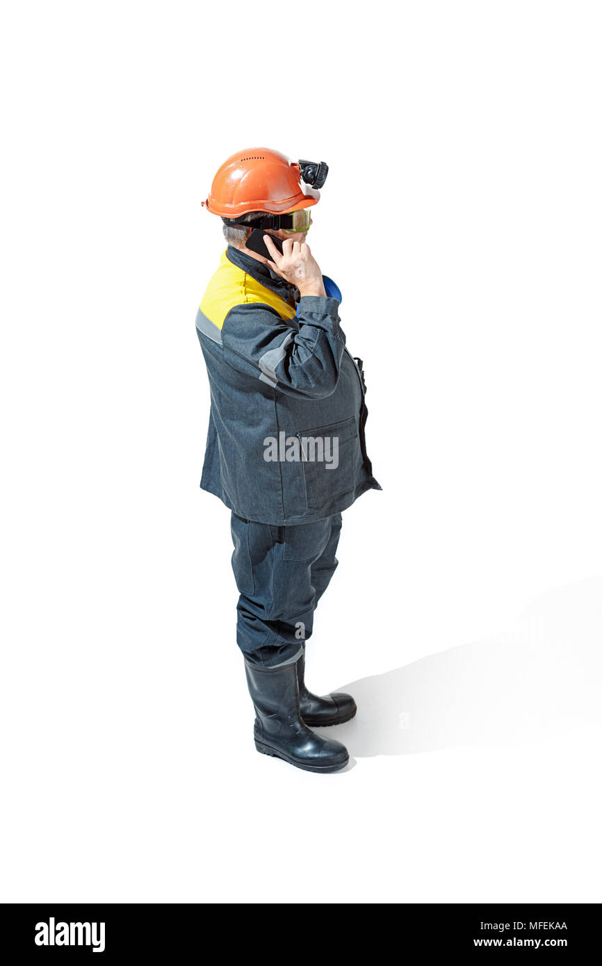 The studio shot of senior bearded male miner standing at the camera on ...