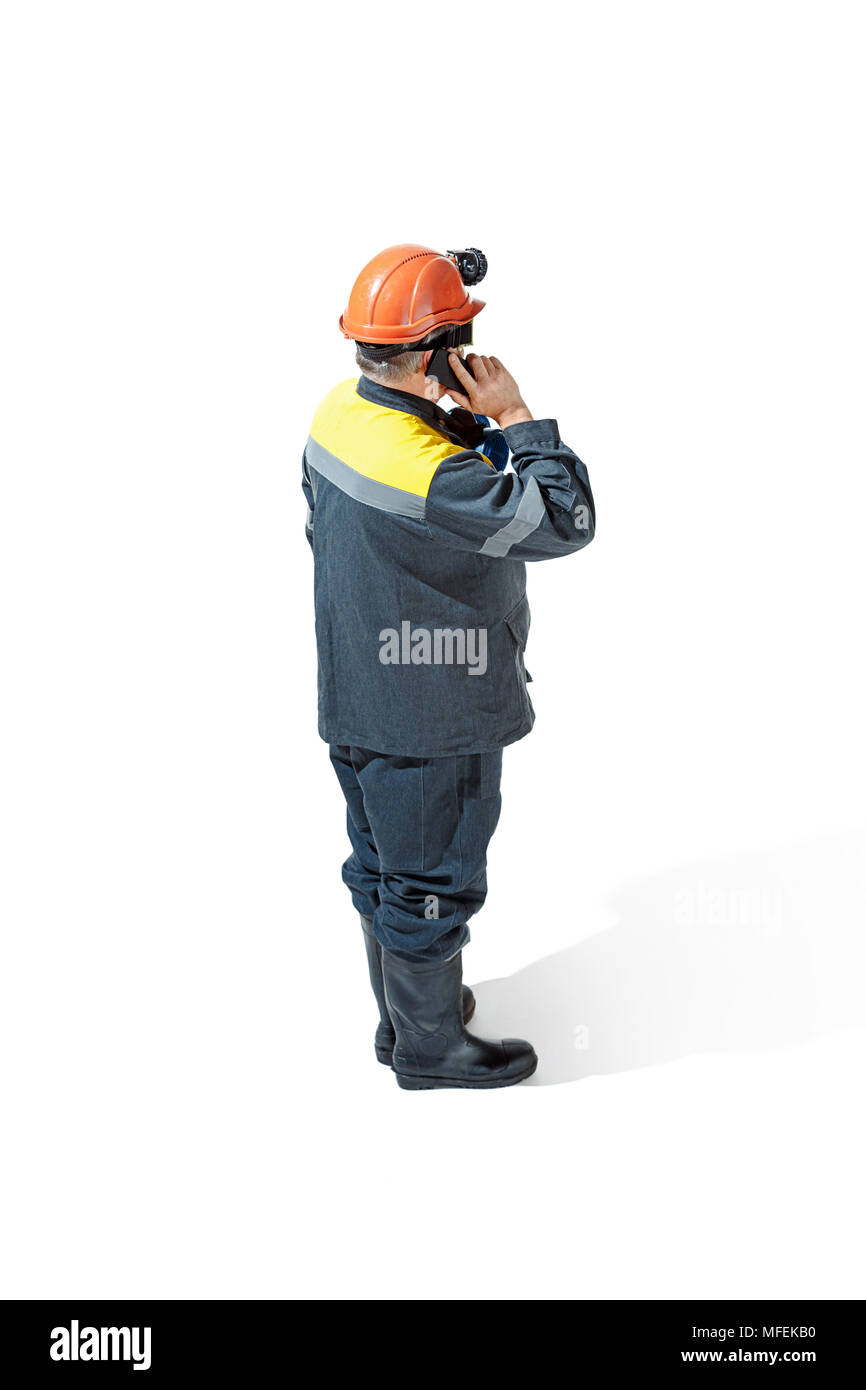 The studio shot of senior bearded male miner standing at the camera on ...