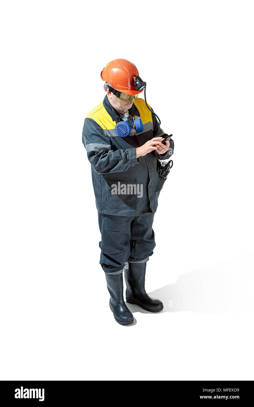 The studio shot of senior bearded male miner standing at the camera on ...