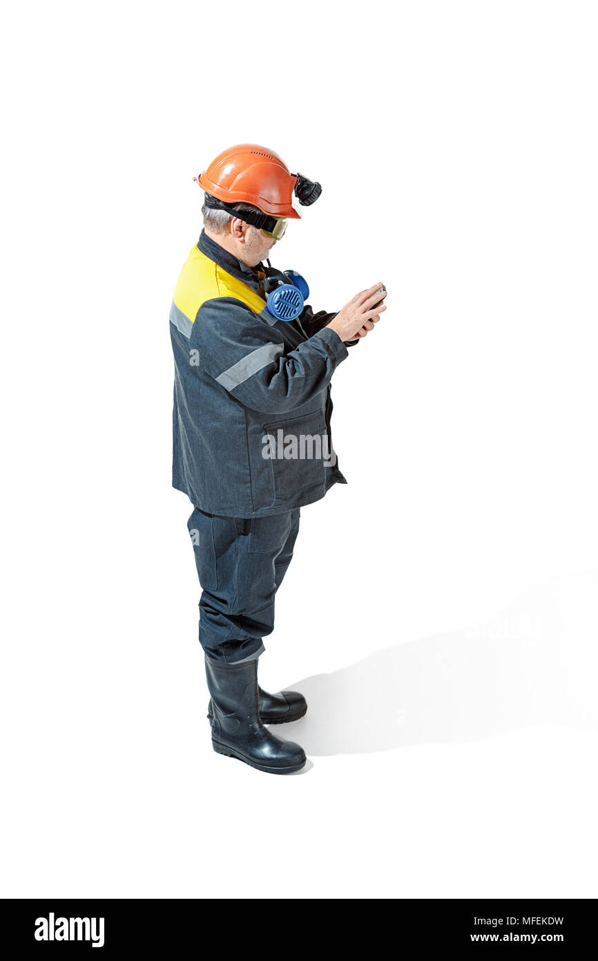 The studio shot of senior bearded male miner standing at the camera on ...