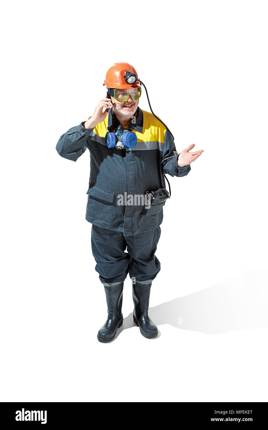 The studio shot of senior bearded male miner standing at the camera on ...
