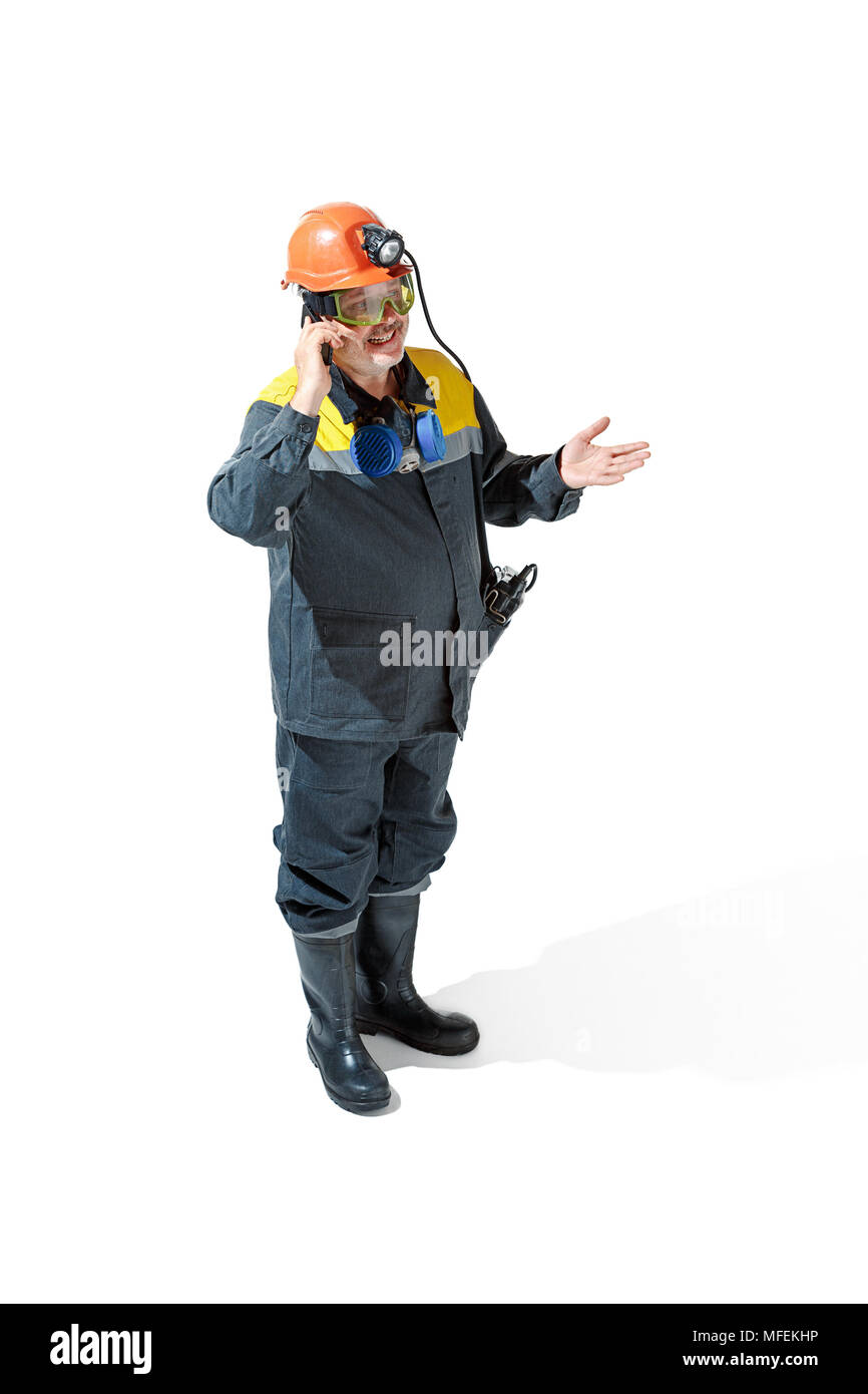 The studio shot of senior bearded male miner standing at the camera on ...