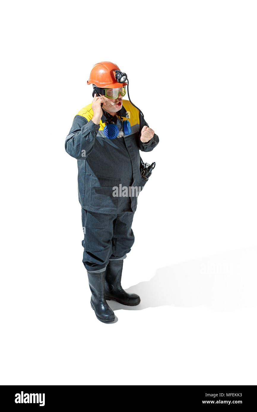 The studio shot of senior bearded male miner standing at the camera on ...