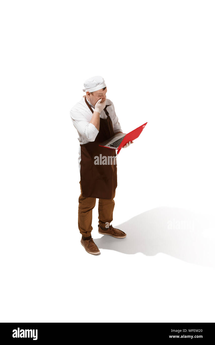 Serious butcher posing with a laptop isolated on white background Stock ...