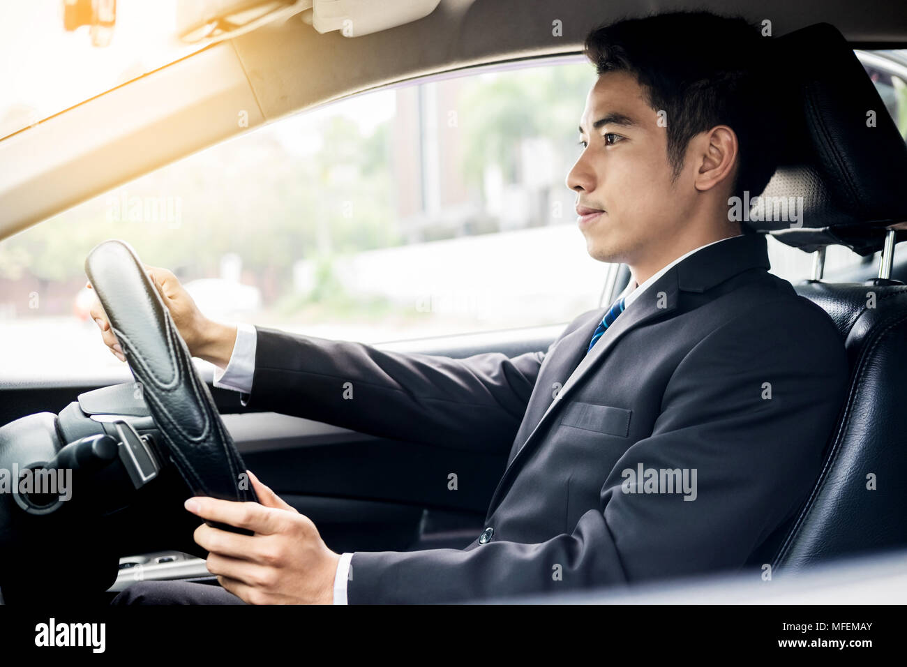 Portrait of a young handsome businessman driving a luxury sports car ...